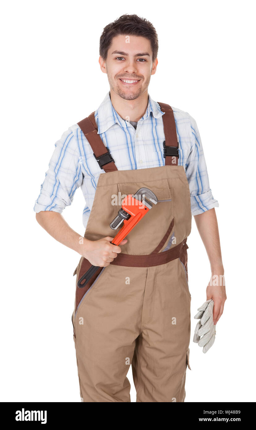 Smiling handsome handyman in work clothes with tool Stock Photo - Alamy