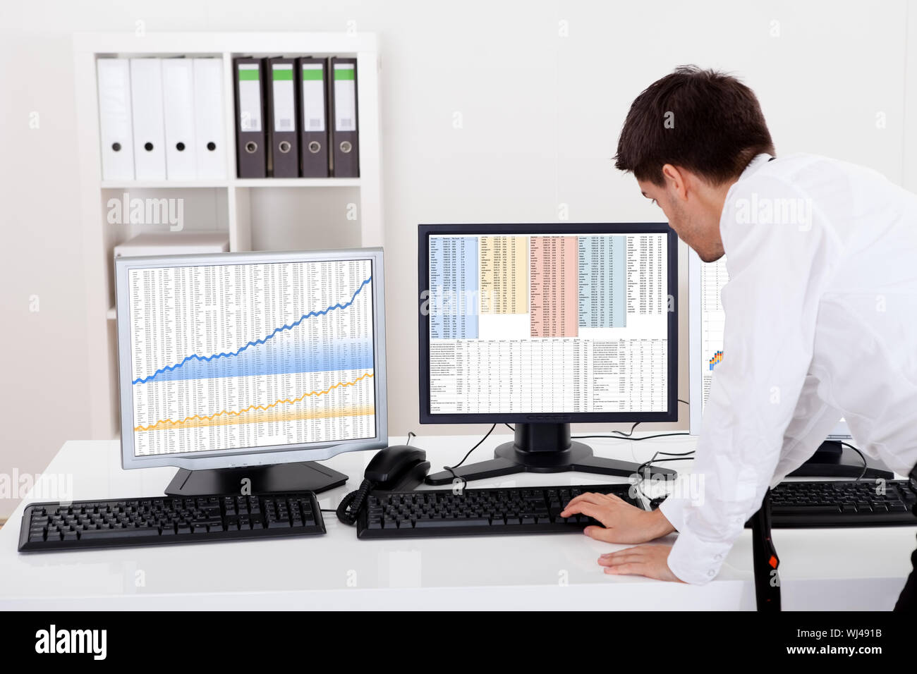 Over the shoulder view of the computer screens of a stock broker ...