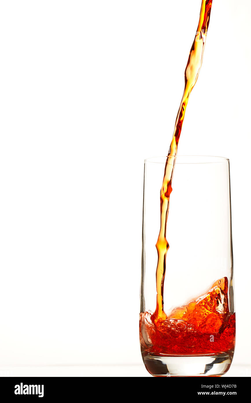 red liquid pouring in glass on white background Stock Photo - Alamy
