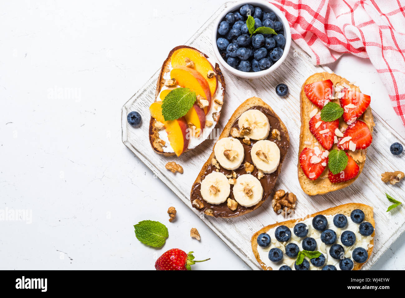 Sweet toast assortment with fresh fruit and berries on white Stock ...