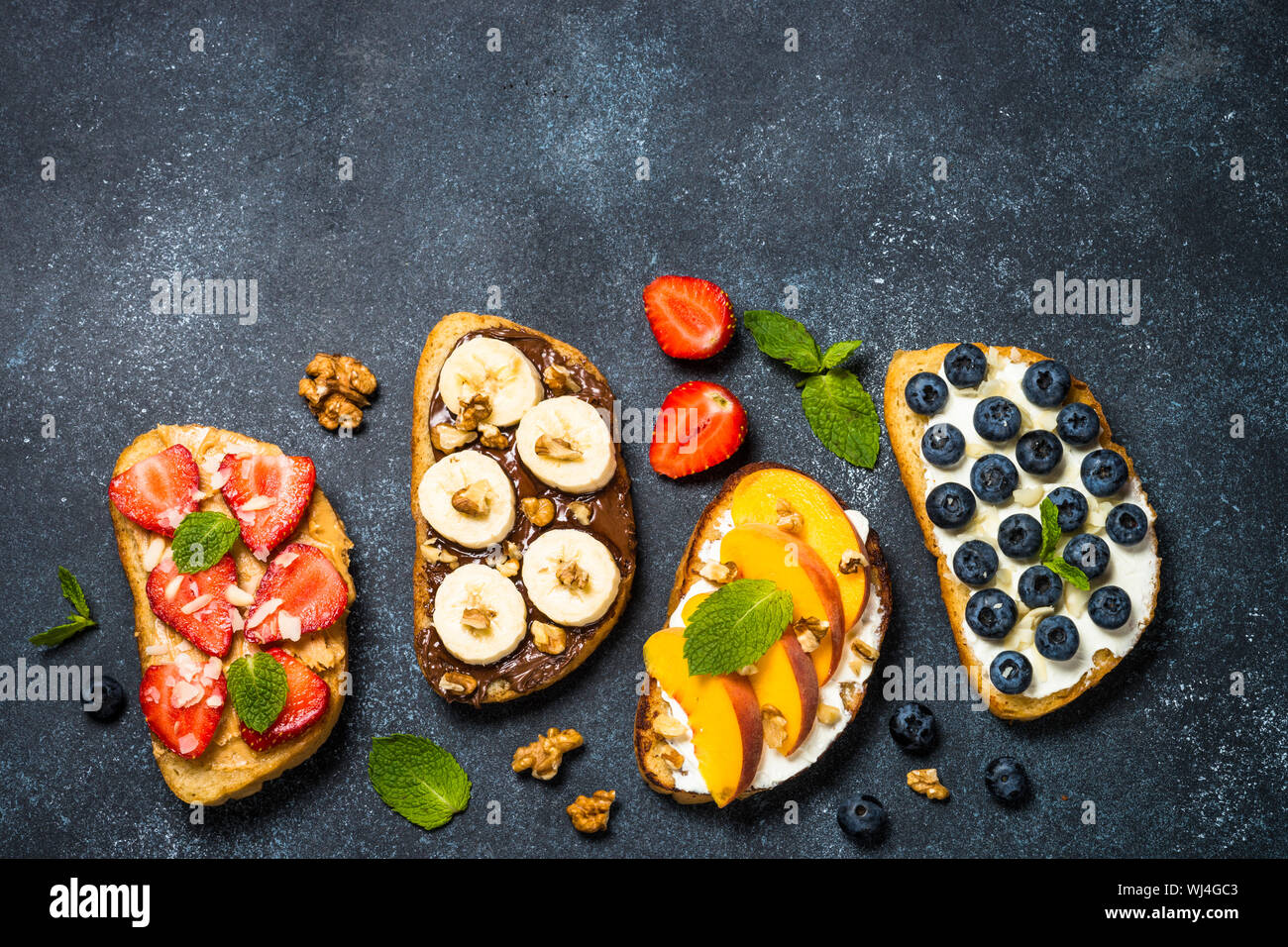 Sweet toast assortment with fresh fruit and berries on black Stock ...