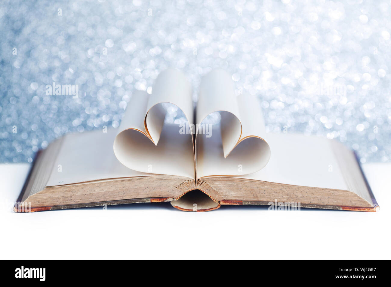 Heart made of blank pages inside a book on glitter background Stock ...