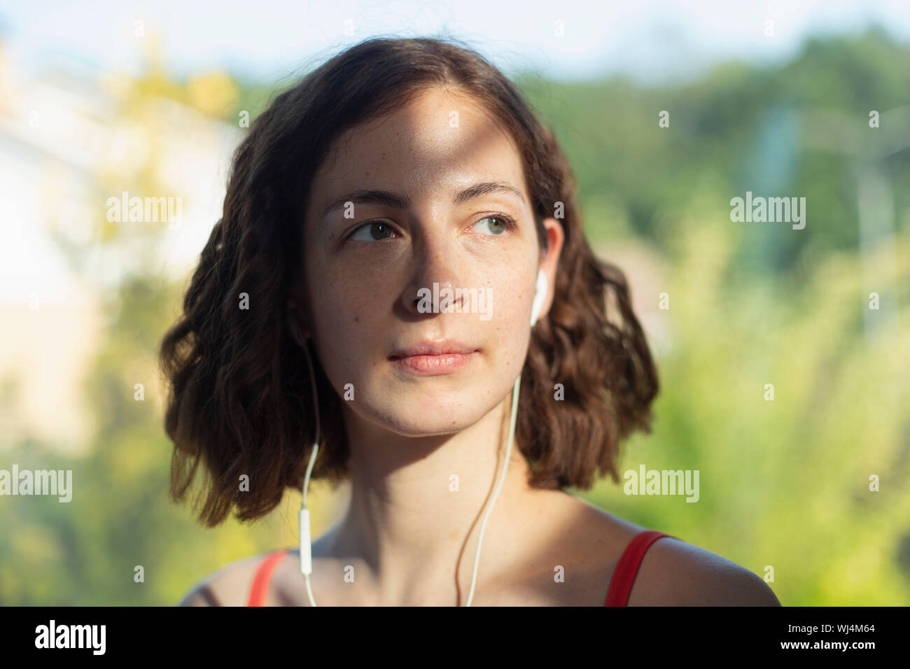 Thoughtful woman listening to music with headphones Stock Photo - Alamy