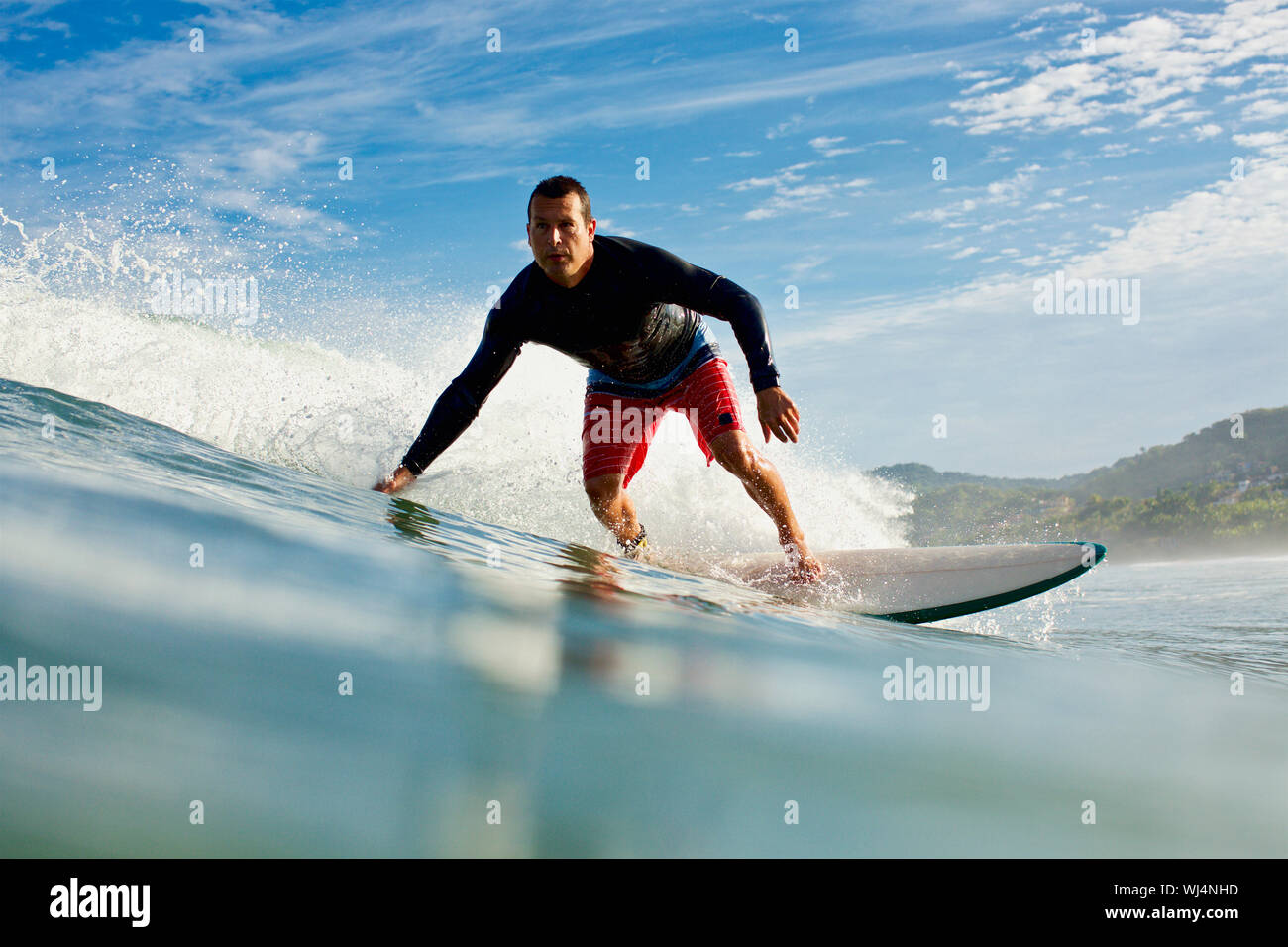 Male surfer riding ocean wave Stock Photo - Alamy