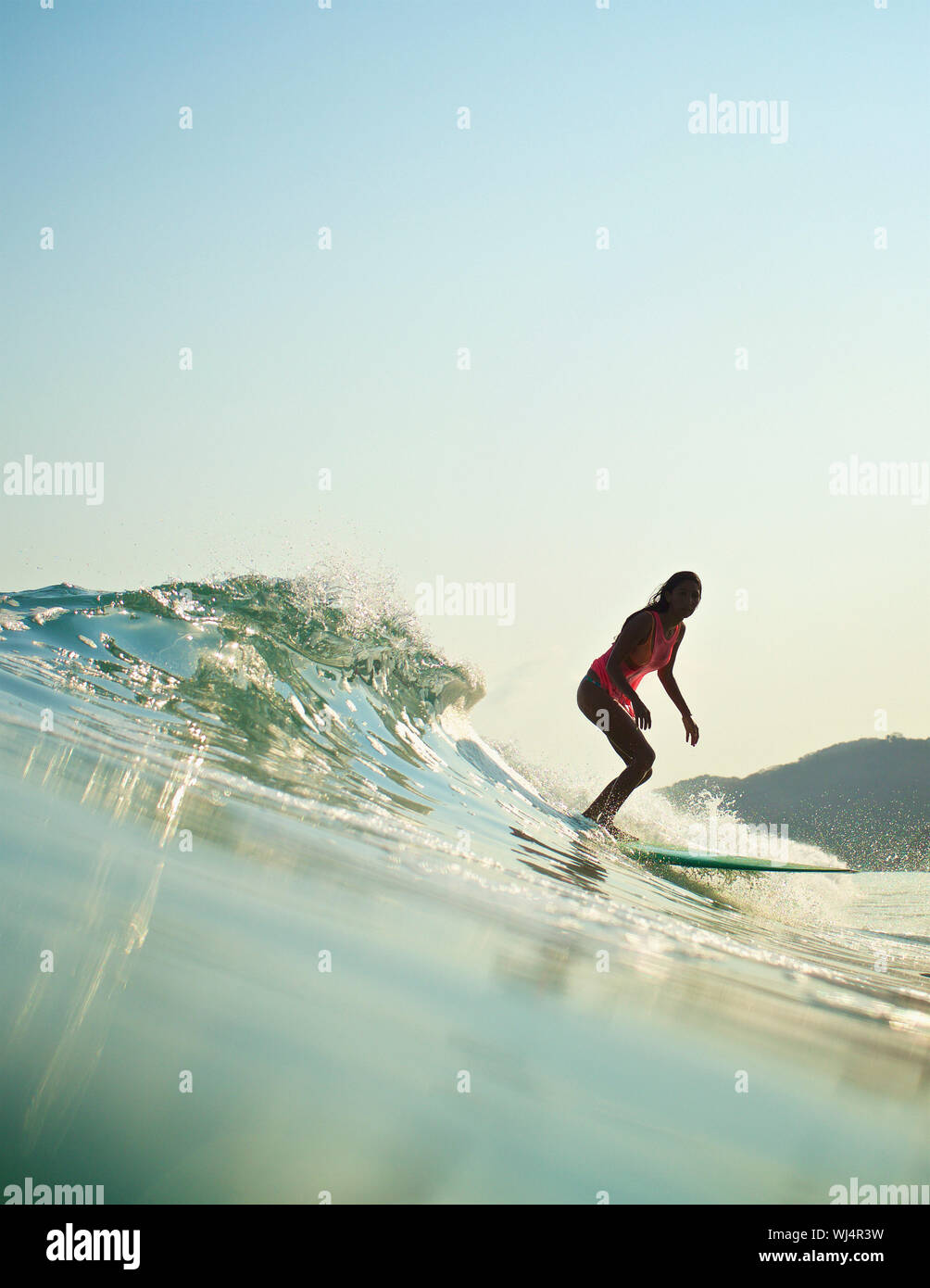 Female surfer riding ocean wave Stock Photo - Alamy