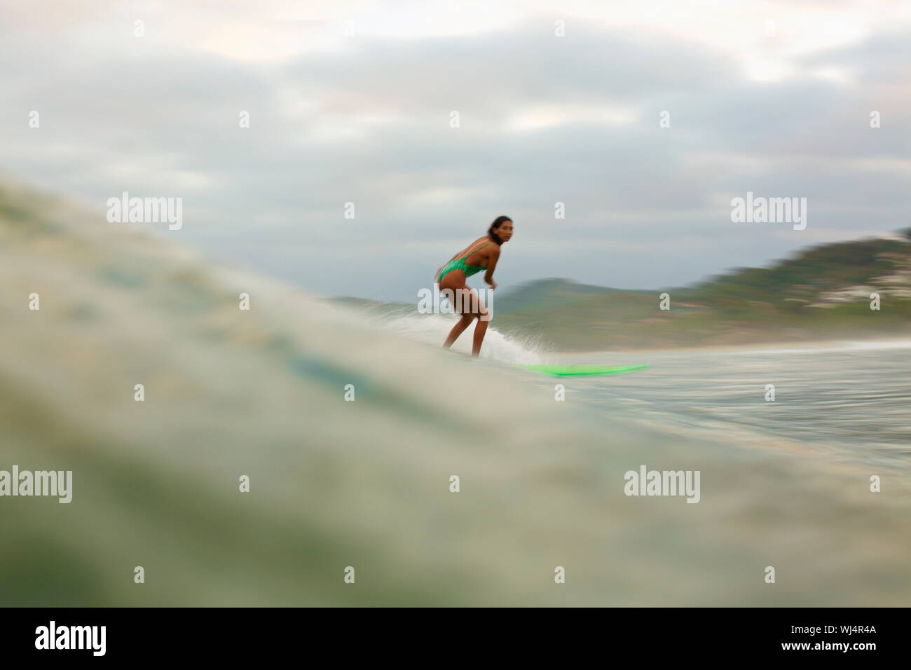 Female surfer riding ocean wave Stock Photo - Alamy