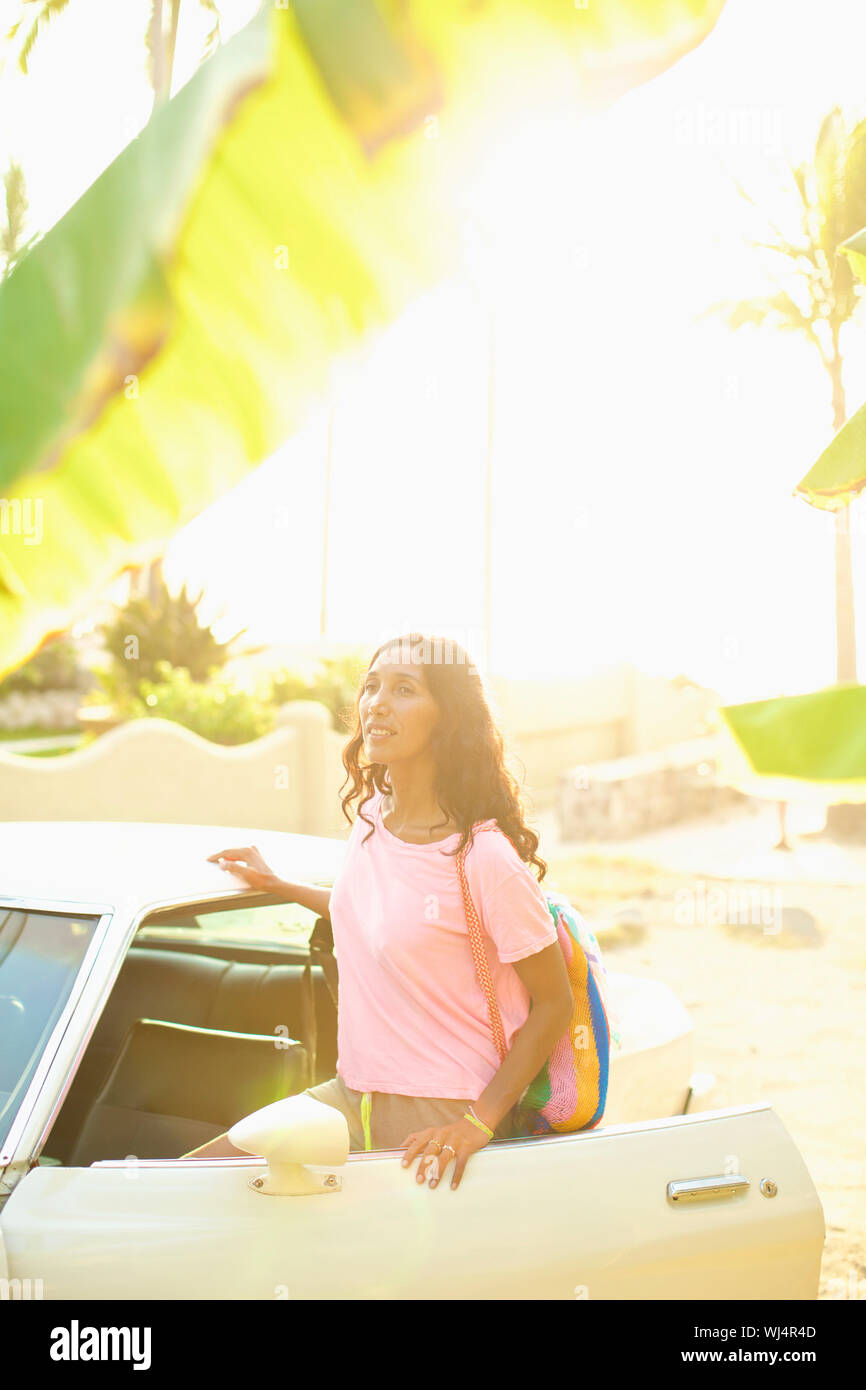 Woman getting into car on sunny beach Stock Photo - Alamy