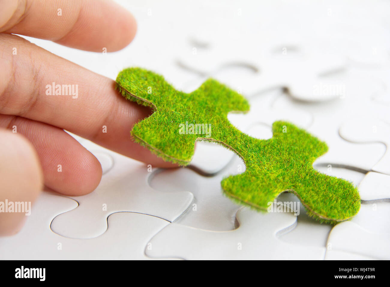 hand holding a green puzzle piece Stock Photo - Alamy