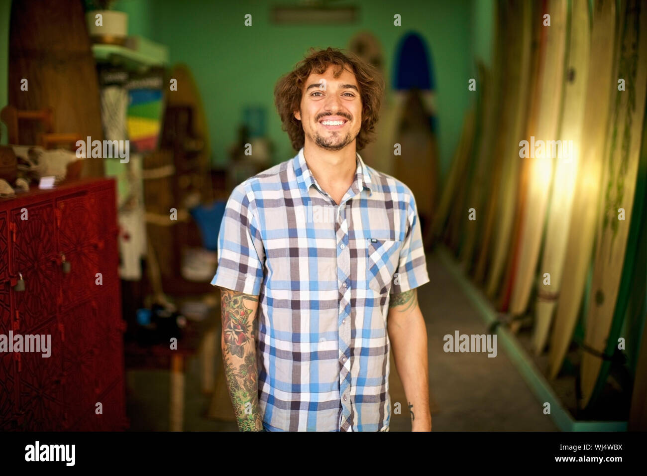 Portrait confident, happy male surf shop owner Stock Photo - Alamy