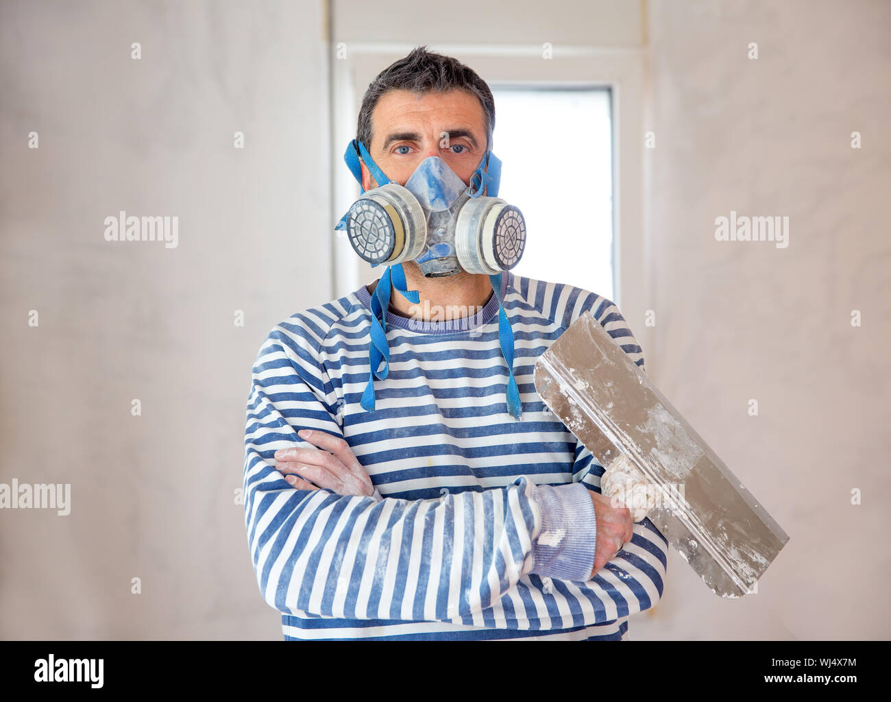 construction funny plastering man mason with protective mask and trowel ...
