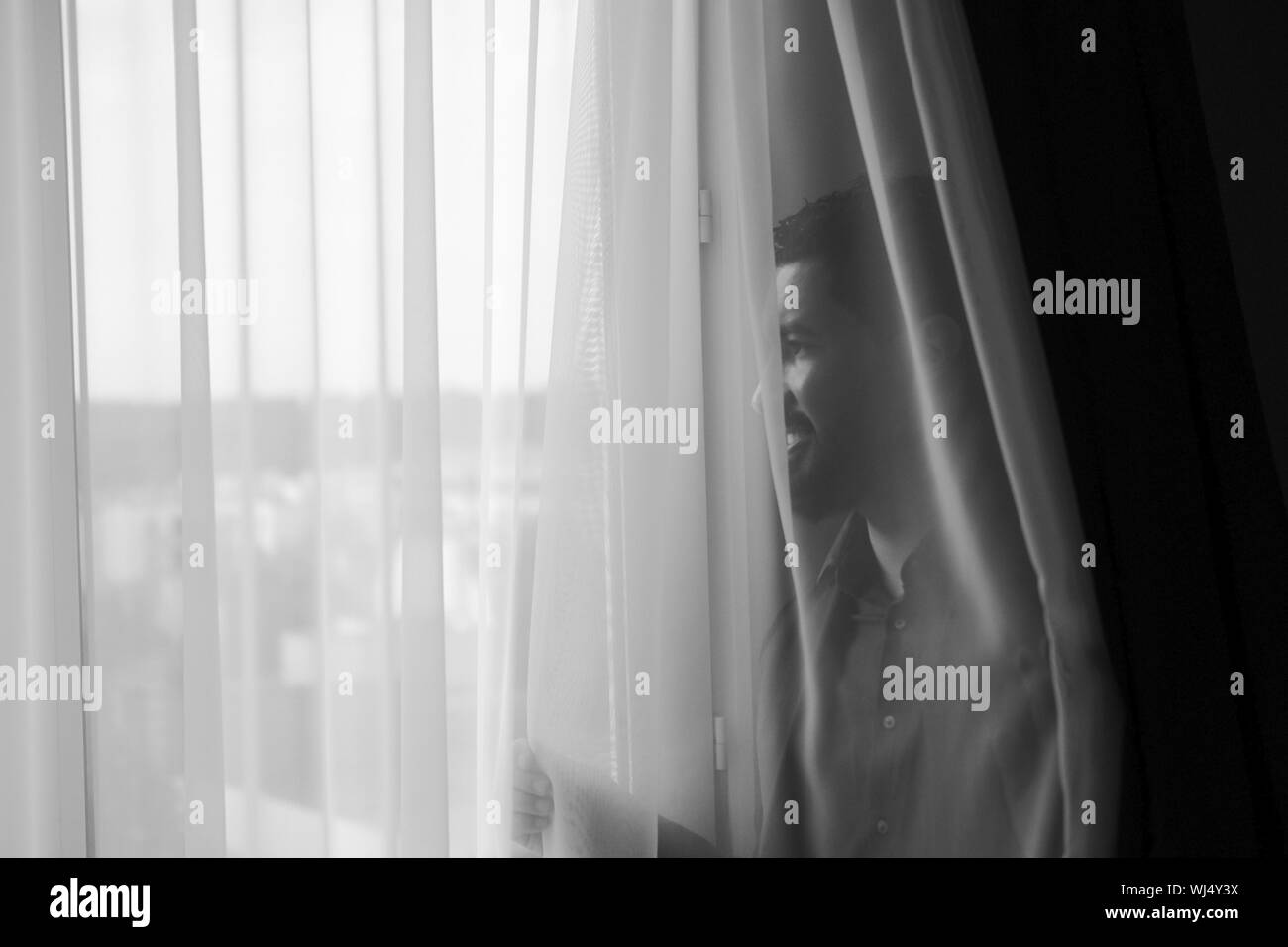 Man looking through window Black and White Stock Photos & Images - Alamy