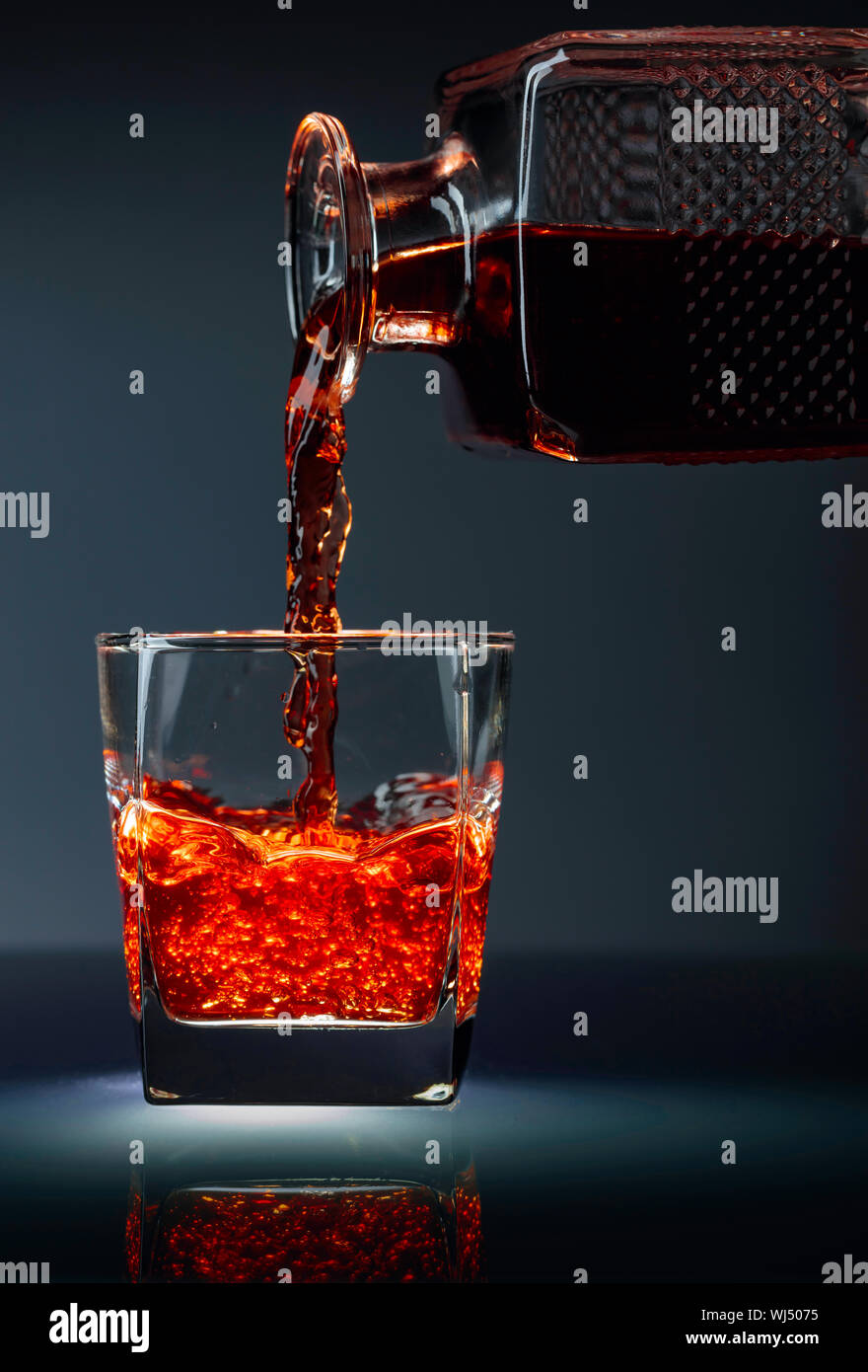 Pouring whiskey or scotch into glass. Alcoholic drink pouring from a ...