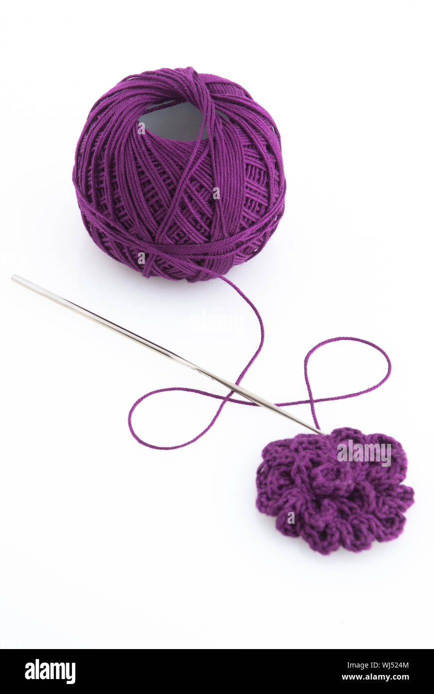 Purple spool and needle on a white background Stock Photo - Alamy