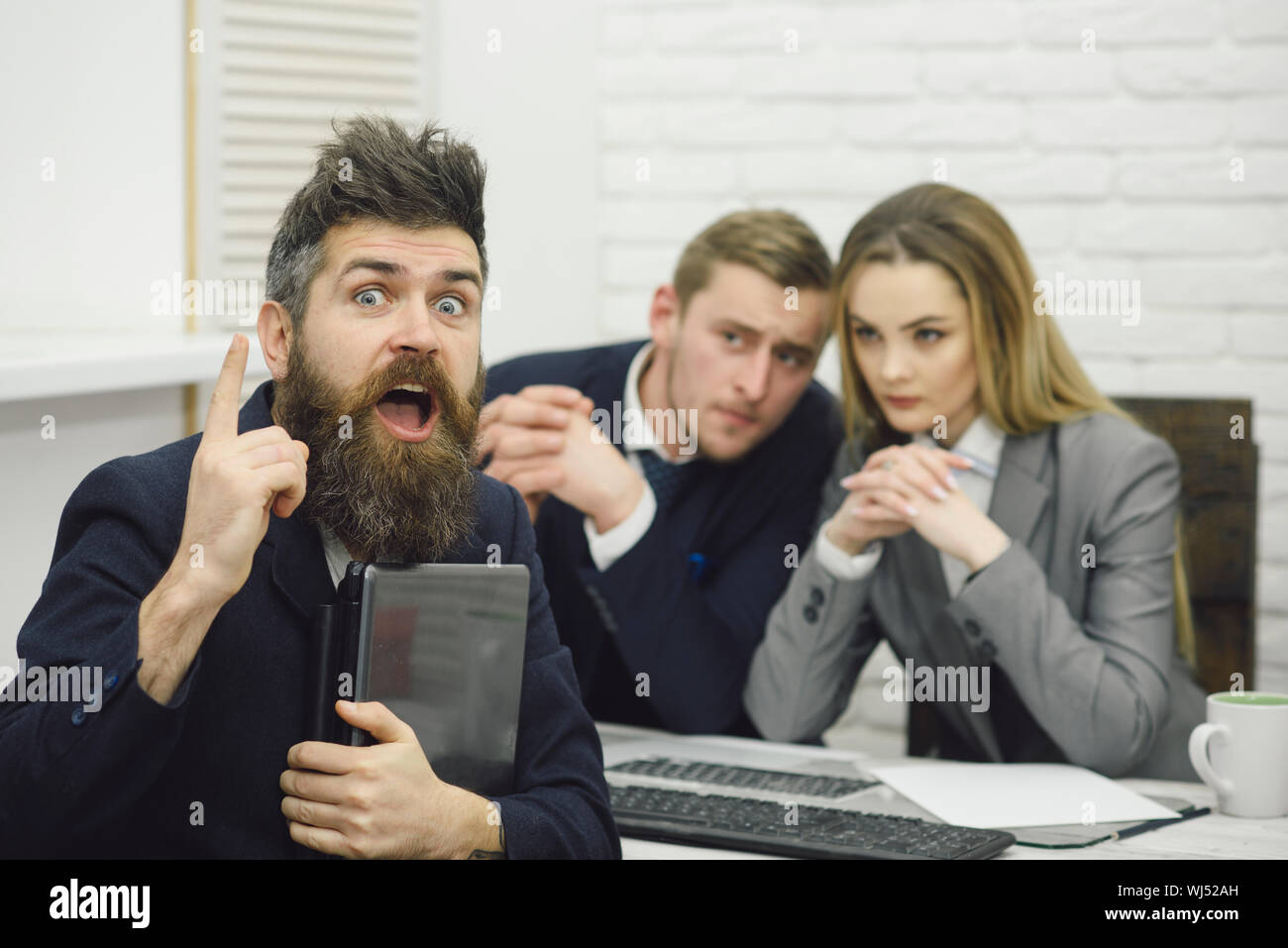 Man with beard on surprised face holds laptop, bosses, coworkers ...