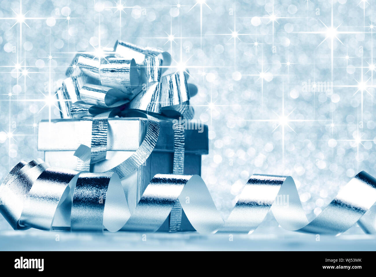 Blue christmas gift on glitter shiny background with stars Stock Photo ...