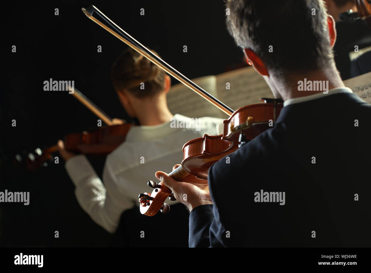 Violinists playing at the concert, rear view Stock Photo - Alamy