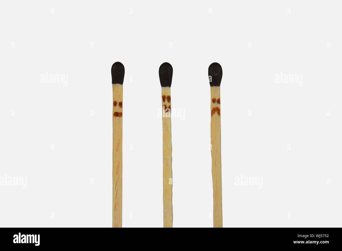 Three matchsticks standing side by side with representing facial ...