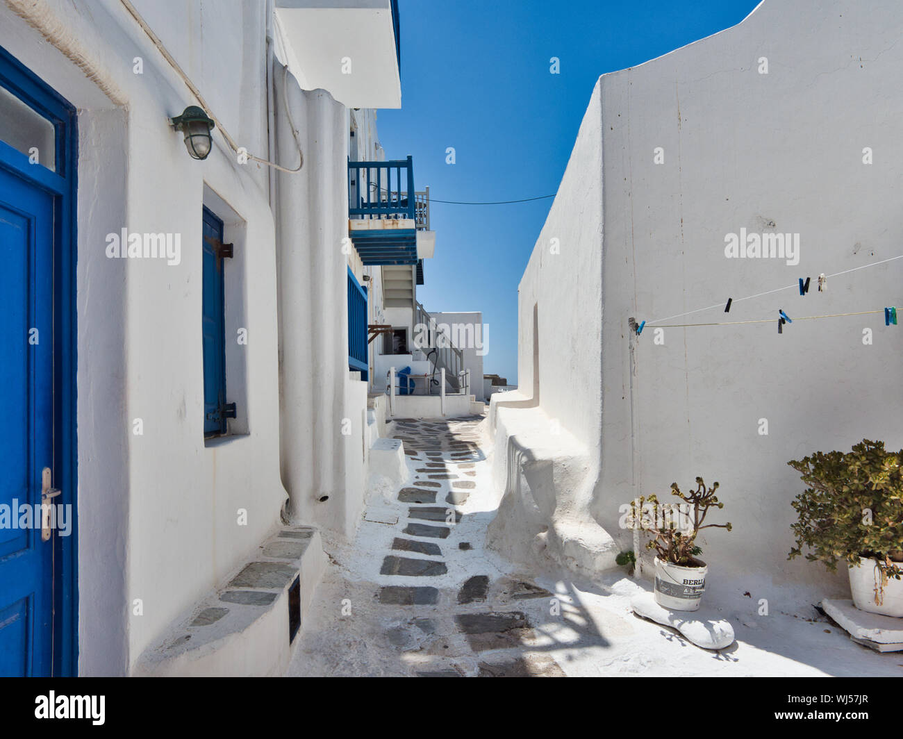 Narrow stone path gong near buildings with white walls on street of ...