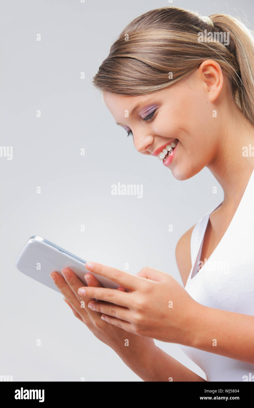 A young beauty looking at her tablet screen and laughing Stock Photo ...