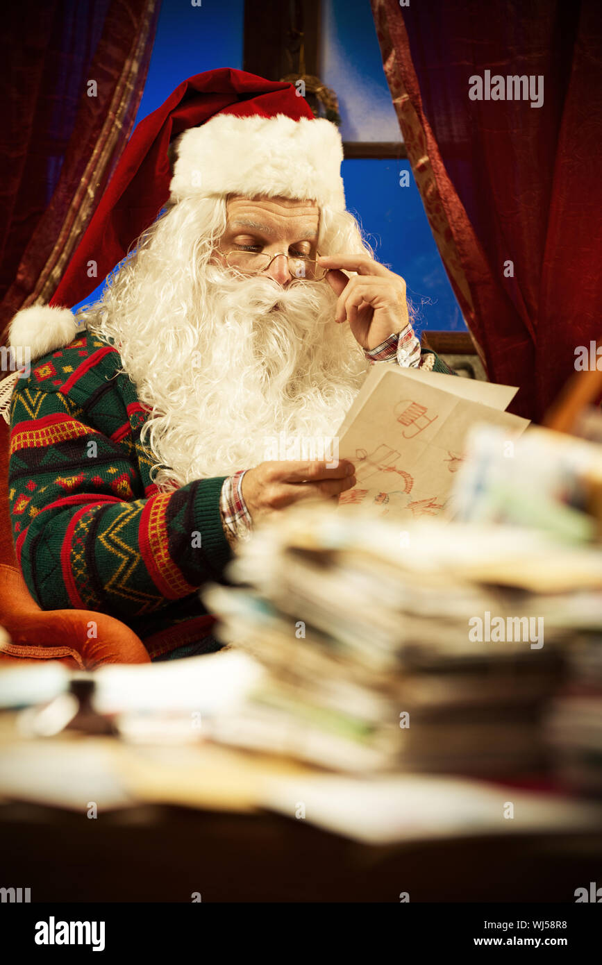 Portrait of Santa Claus reading a Christmas letter Stock Photo - Alamy