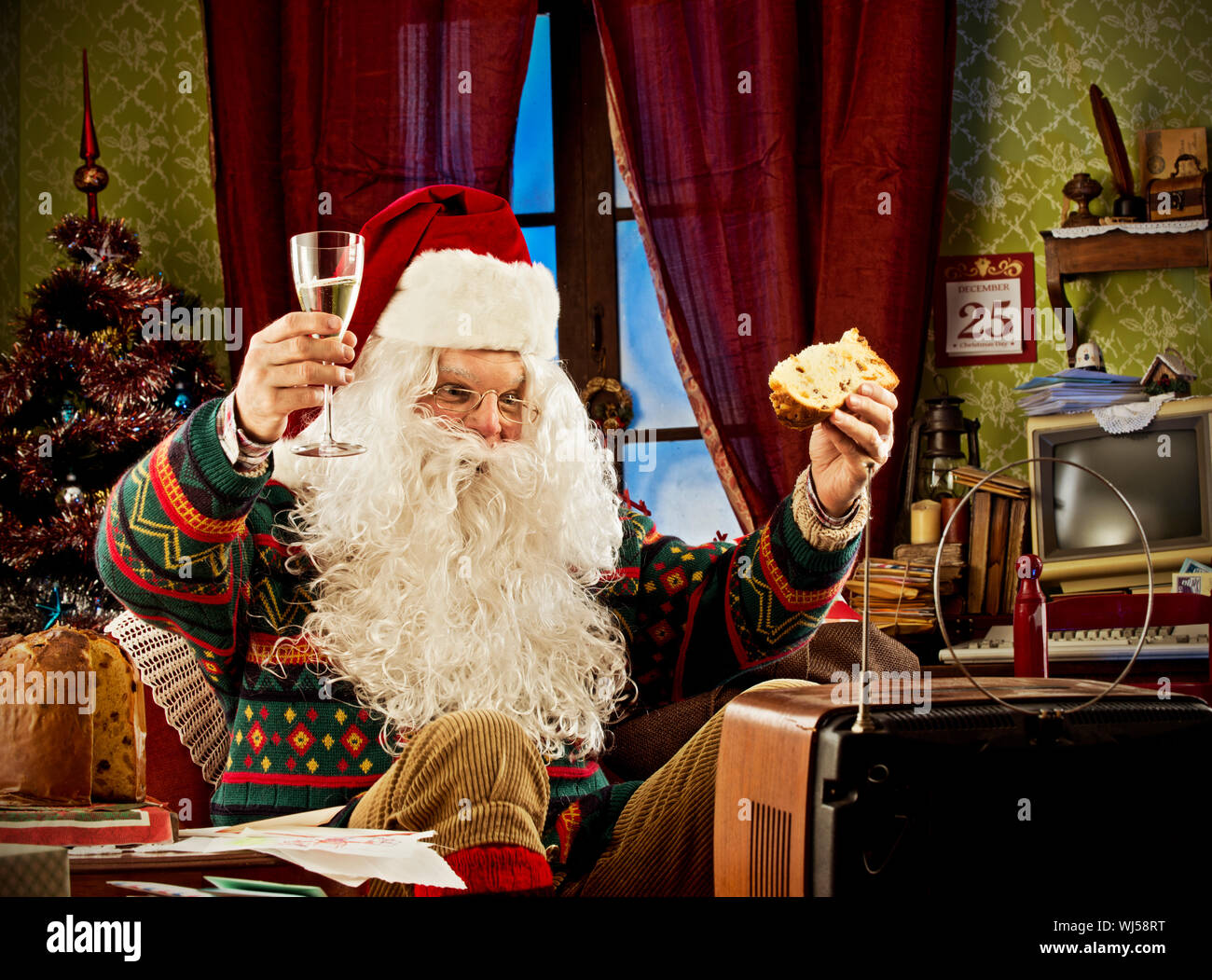 Portrait of Santa Claus watching tv, celebrating with a glass of ...