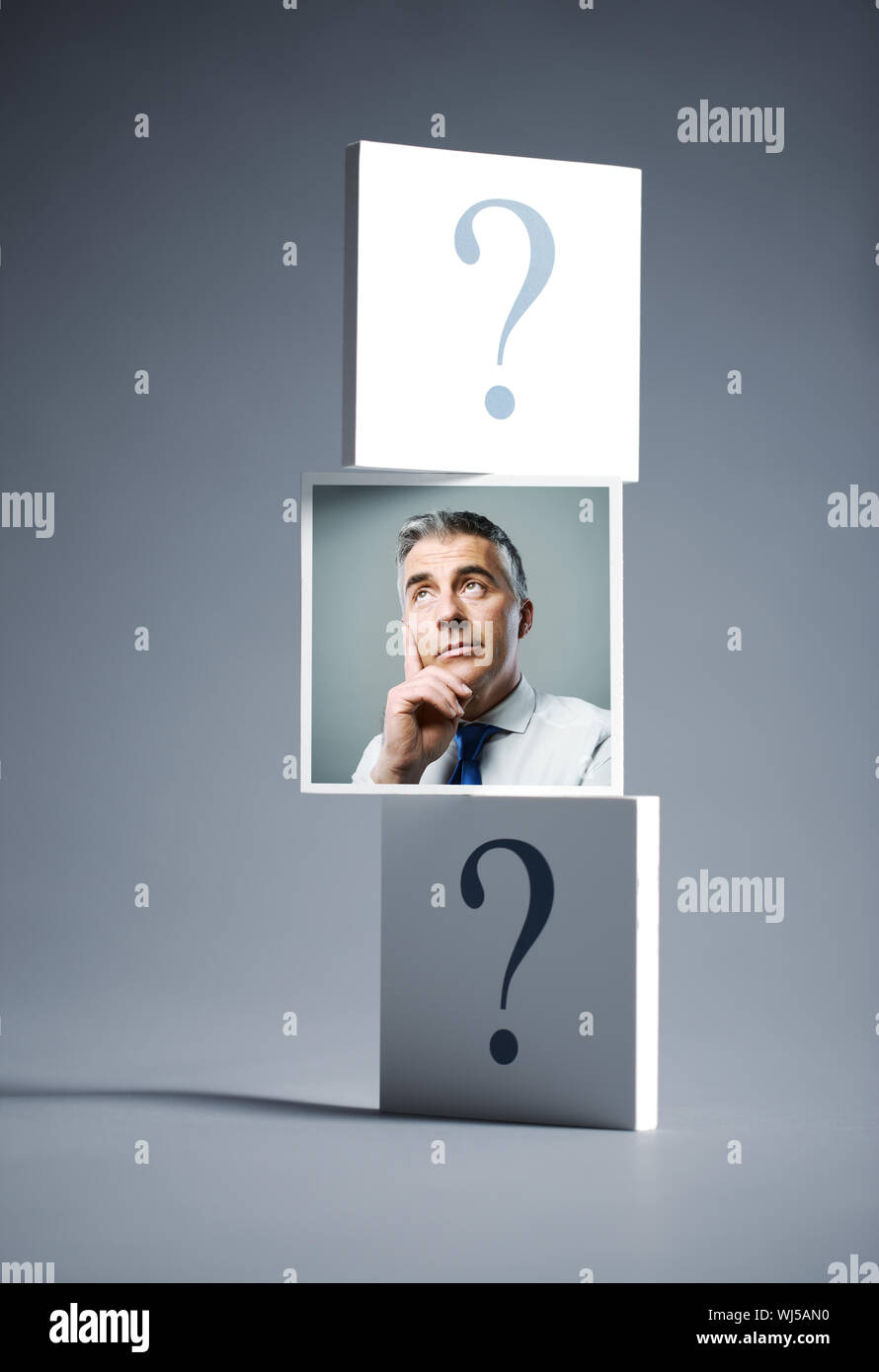 Portrait of a confused businessman surrounded by question marks Stock ...