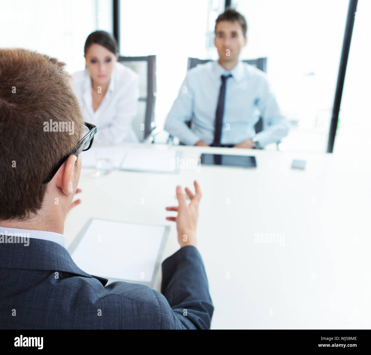 Two business people having job interview with young man Stock Photo - Alamy