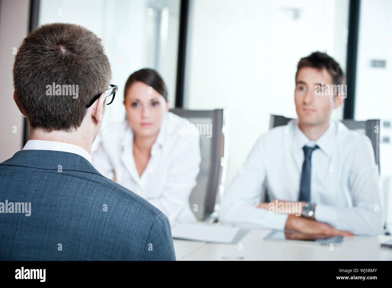 Two business people having job interview with young man Stock Photo - Alamy