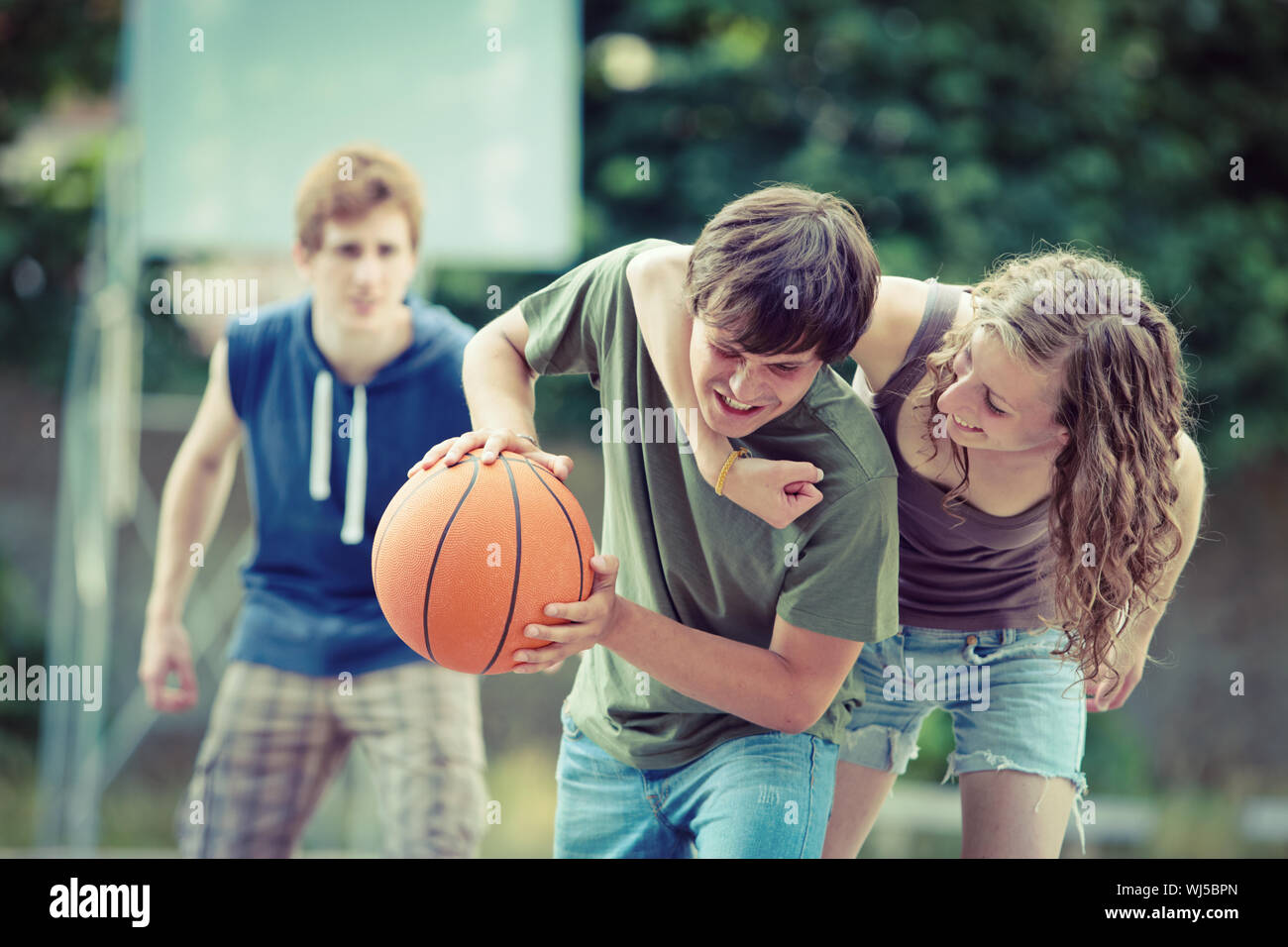 Teens playing a game of basketball on an outdoor court Stock Photo - Alamy