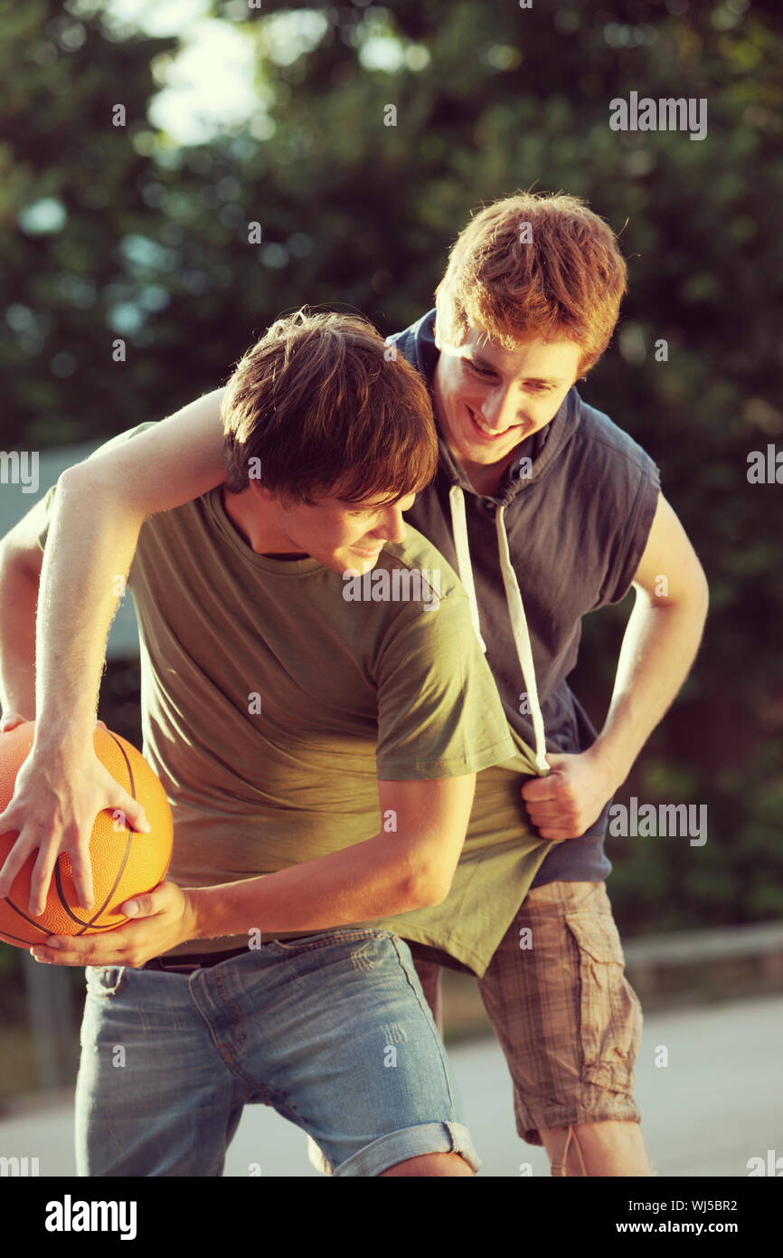 Two friends playing a game of basketball on an outdoor court Stock ...