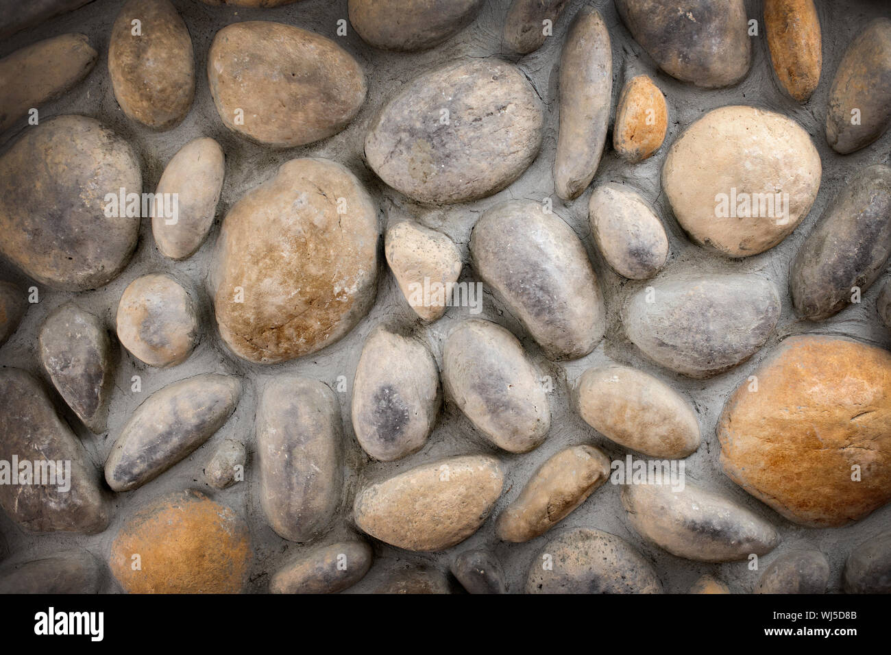 Wall of rocks and stones in cement background Stock Photo - Alamy