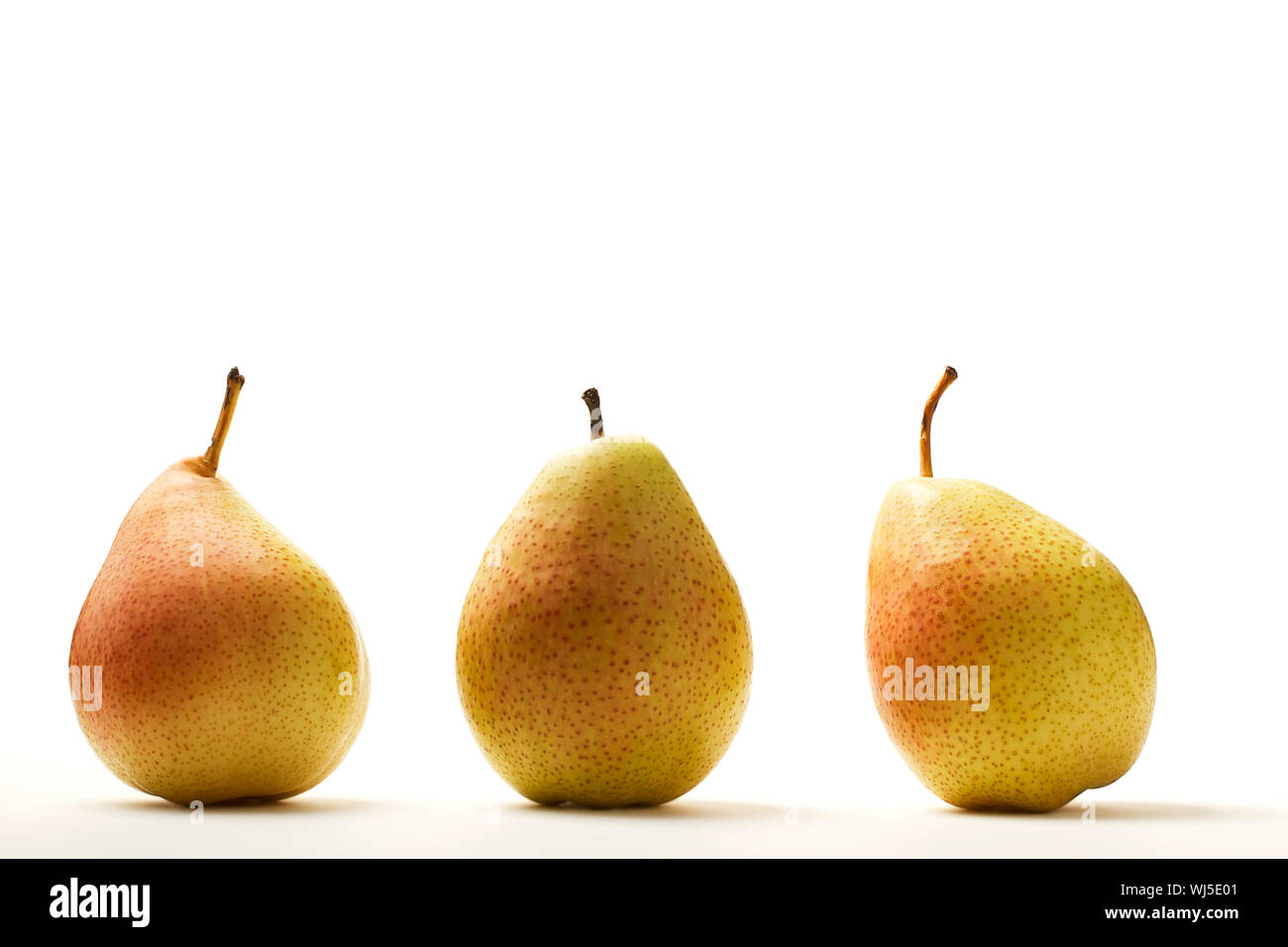 three pears in a row on white background Stock Photo - Alamy
