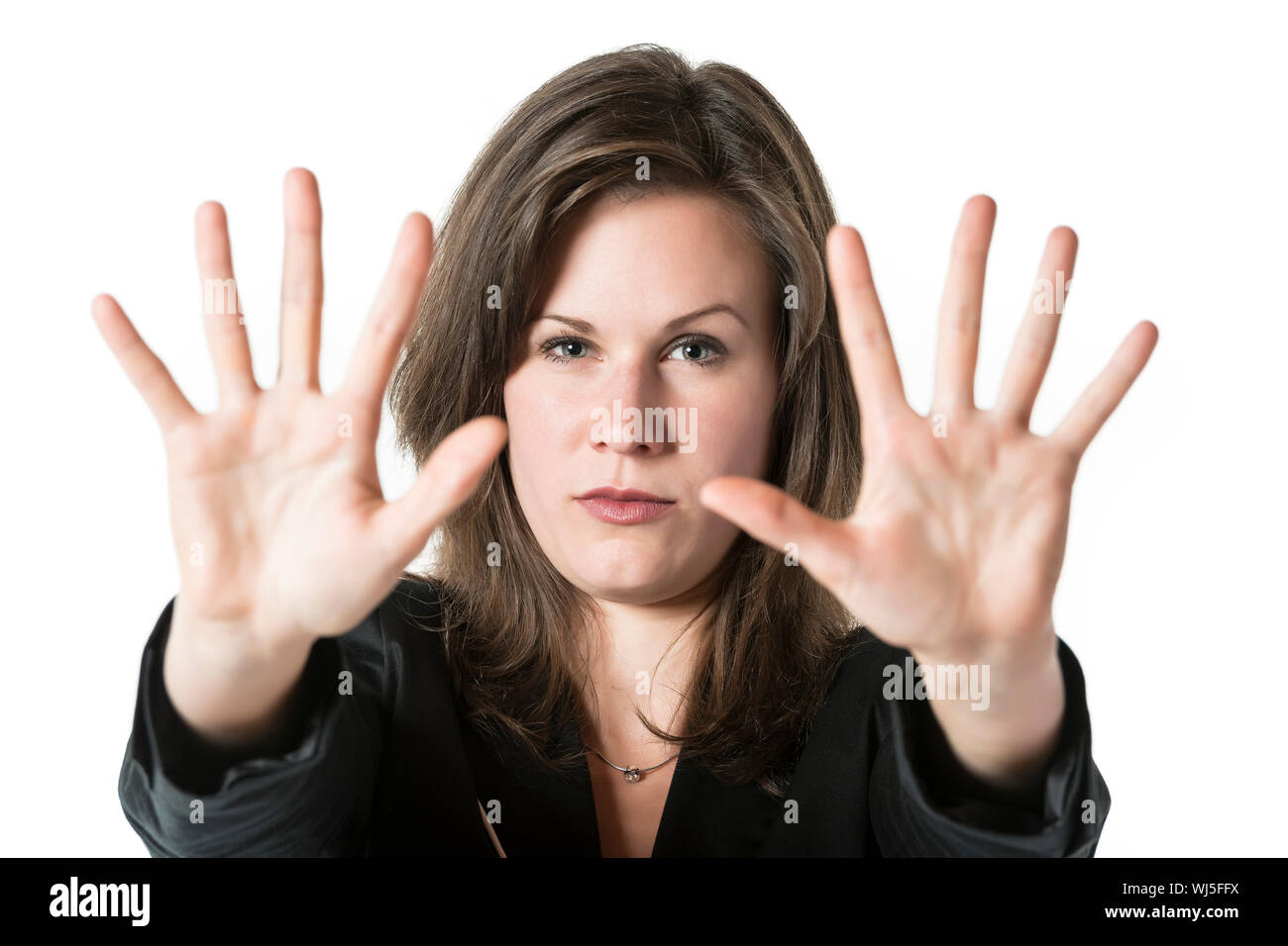 Business woman in black suit holds both hand up to stop someone or ...