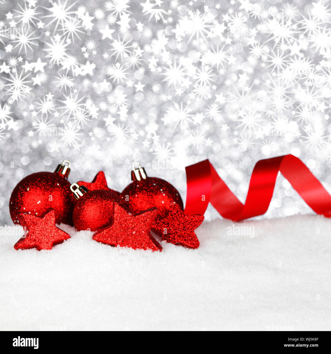 Shiny red christmas decoration on snow over silver glitter background ...