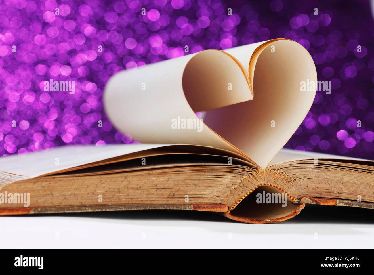 Heart made of blank pages inside a book on glitter background Stock ...