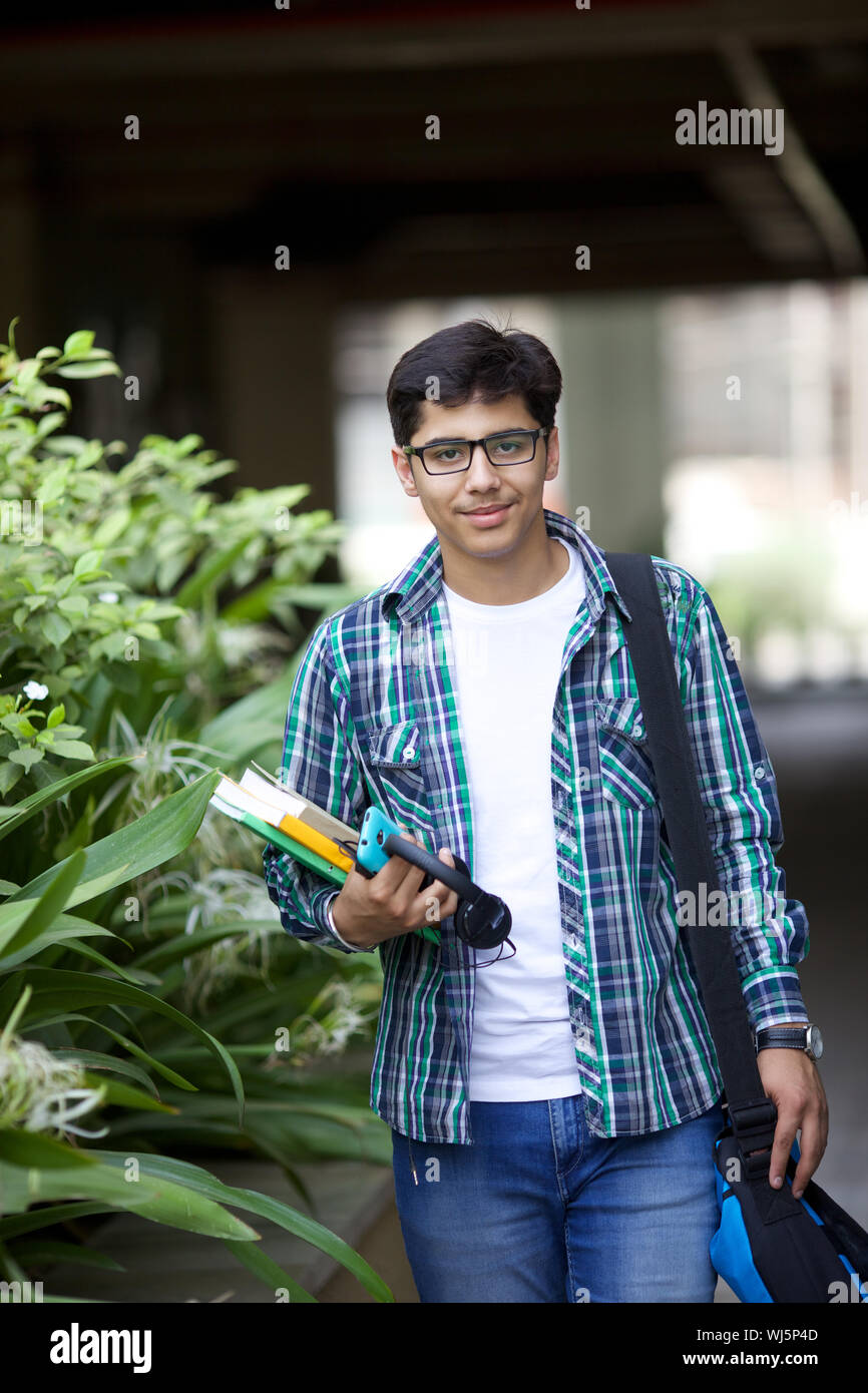 College student walking with books Stock Photo - Alamy