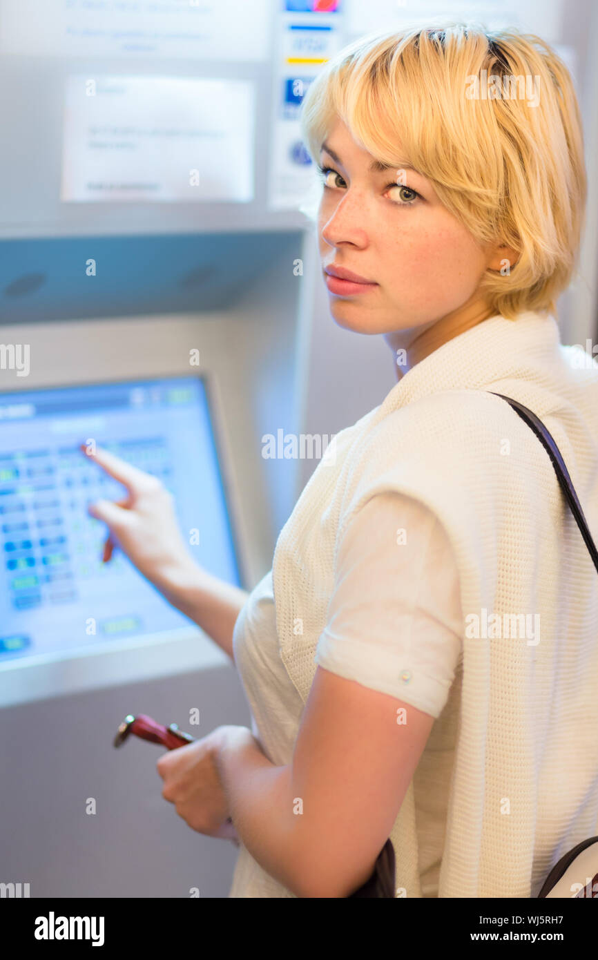 Lady buying a railway ticket at the automatic ticket vending machine ...