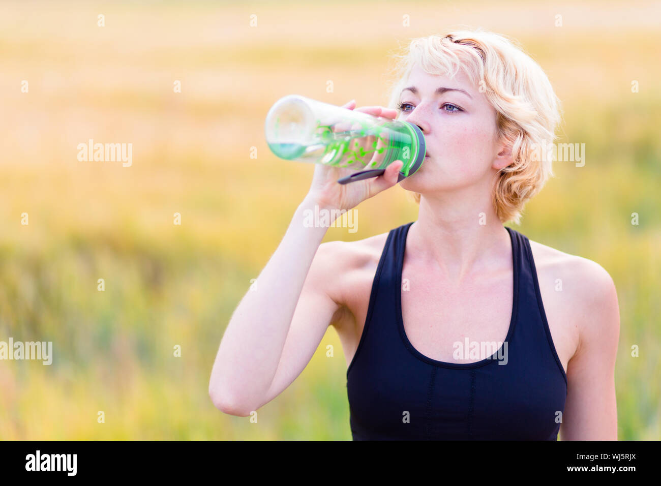 Lady drinking from the bottle during outdoor activities Stock Photo - Alamy