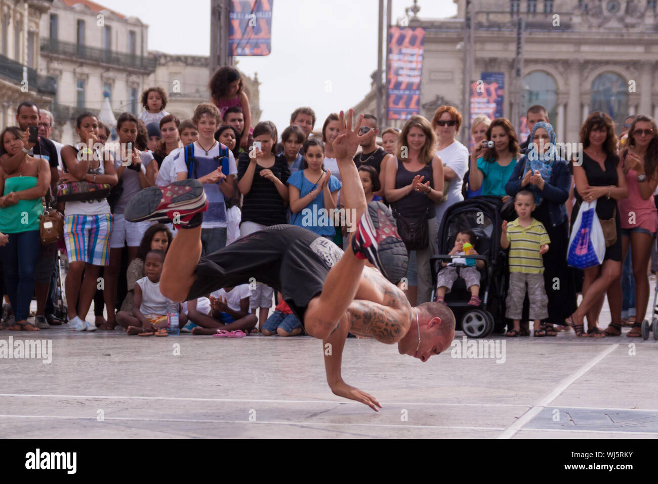 Street performer breakdancing in front of the random crowd Stock Photo ...