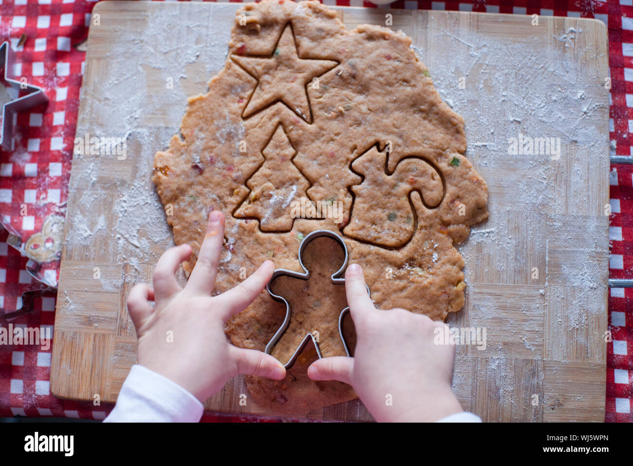 Child hands making from dough gingerbread man Stock Photo - Alamy