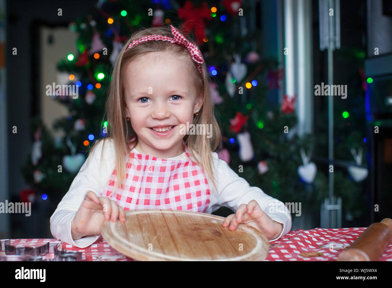Adorable little girl baking gingerbread Christmas cookies at home Stock ...