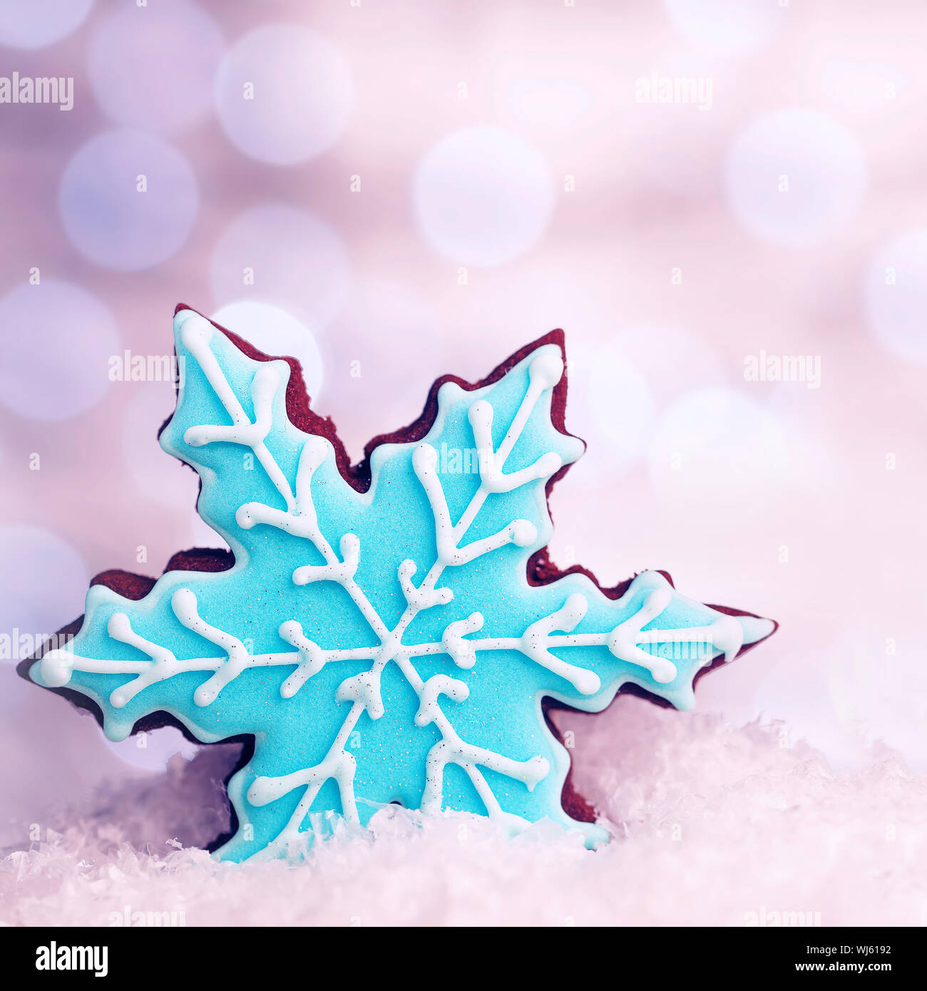 Tasty blue snowflake shaped cookie in snow decoration, traditional ...