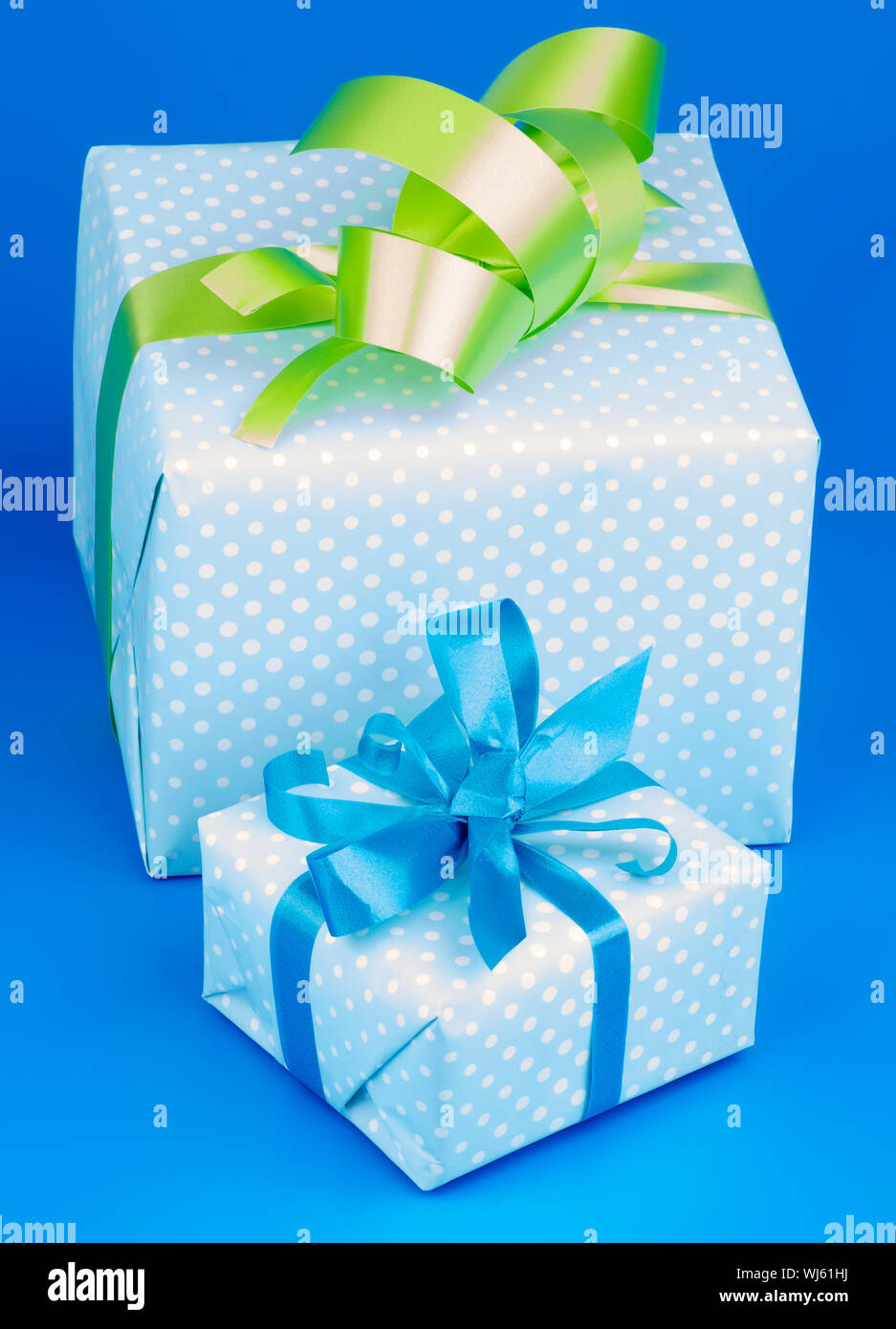 Two Gift Boxes with Green and Blue Bow isolated on Blue background ...