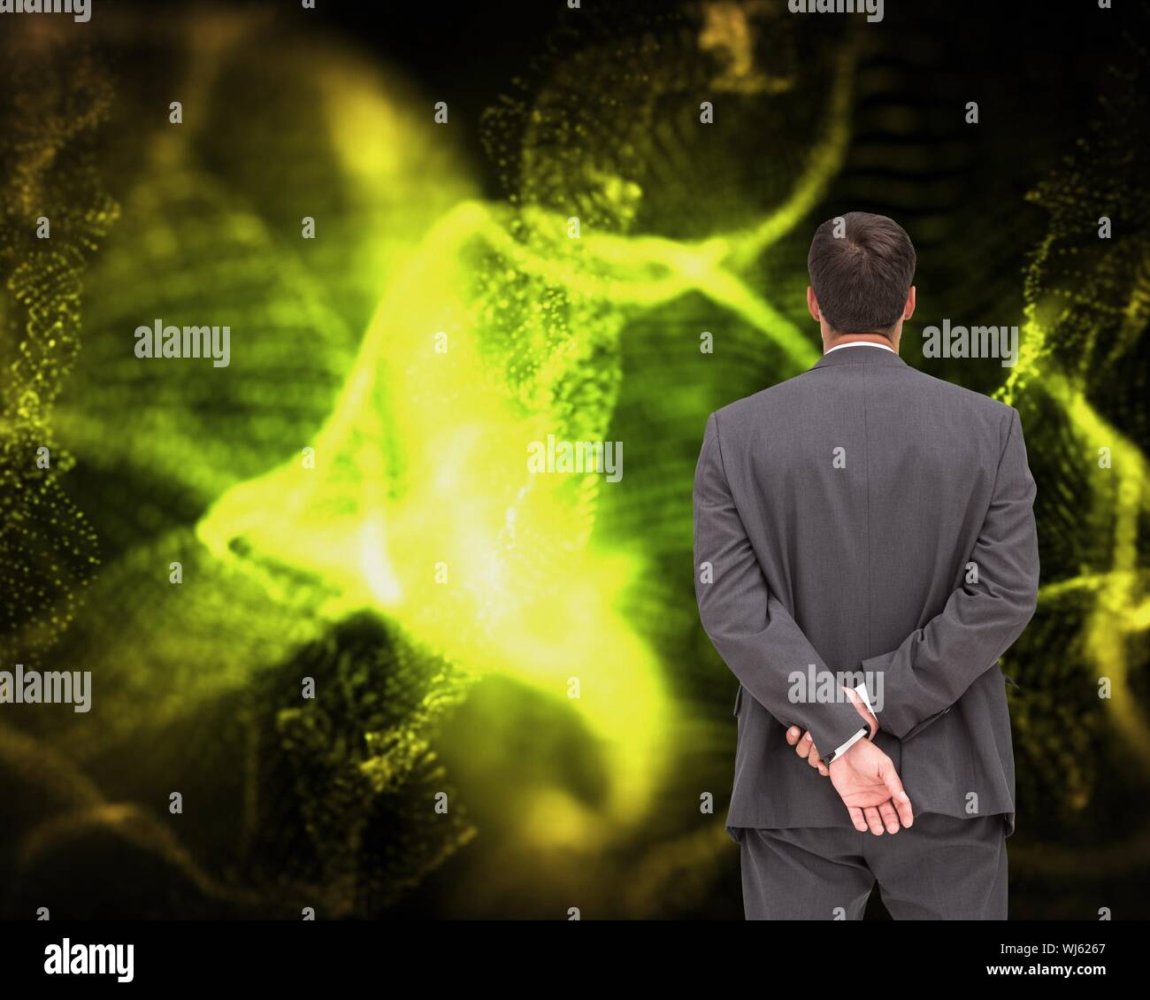 Composite image of businessman standing with hands behind back on black ...