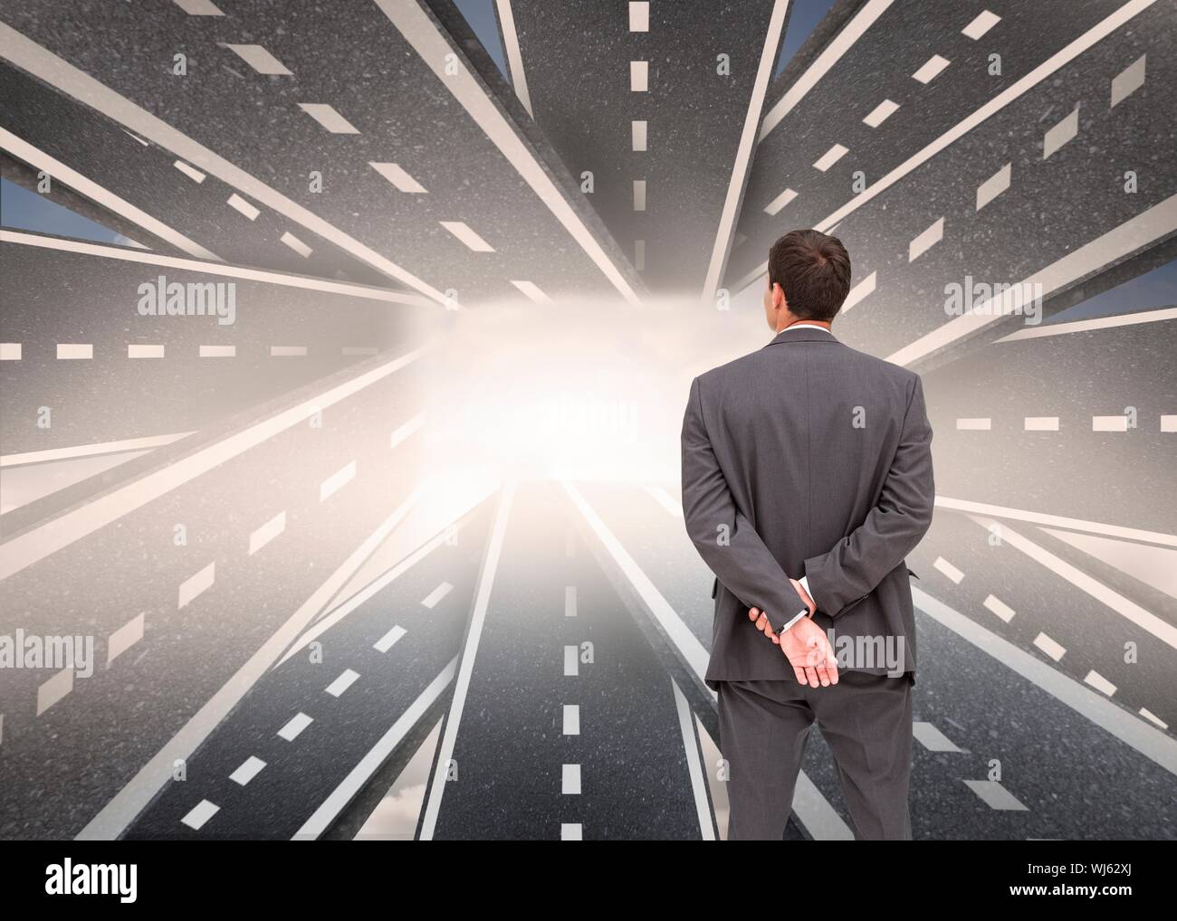 Composite image of businessman standing with hands behind back with ...