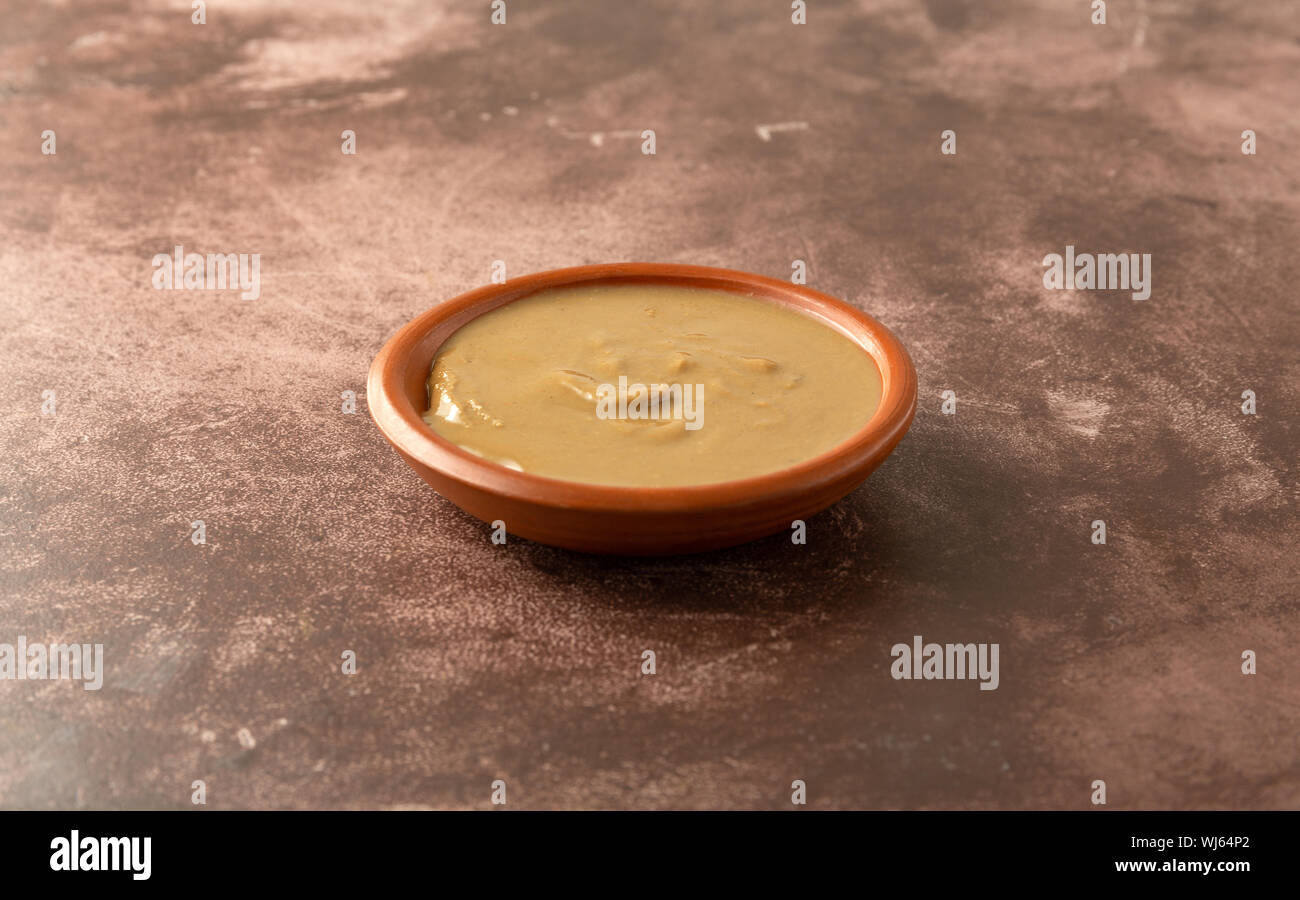 Side view of organic cashew nut butter in a small bowl on a mottled ...