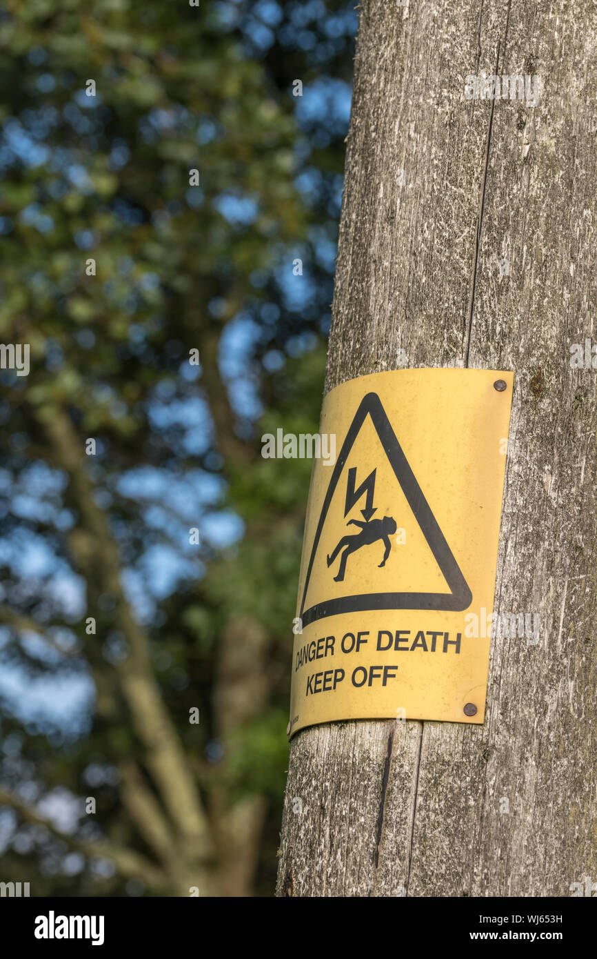 Electricity death hazard yellow triangle warning sign on rural ...