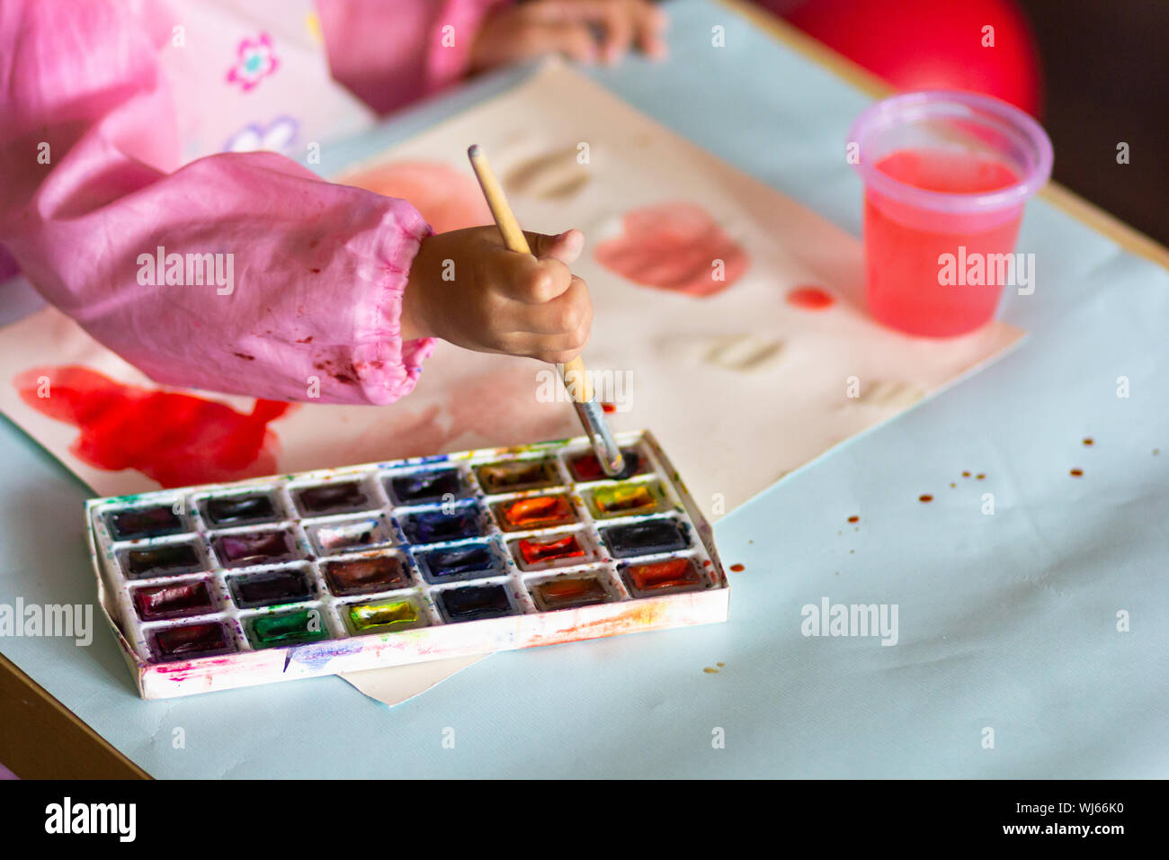 child paints with brush and colorful paints on paper Stock Photo - Alamy
