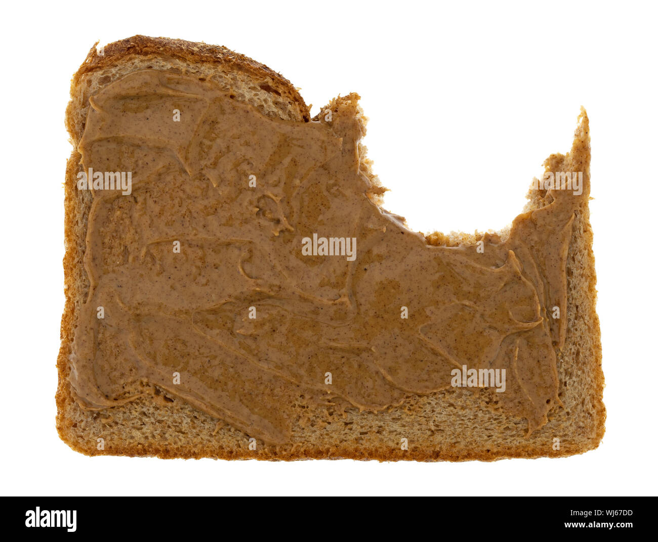 Top view of bitten slice of wheat bread with almond and coconut butter ...