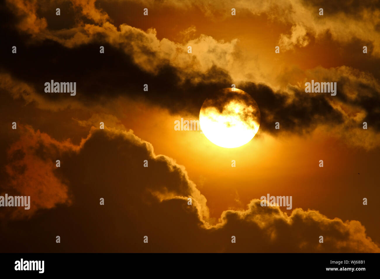 Morning sun behind cloud Stock Photo - Alamy